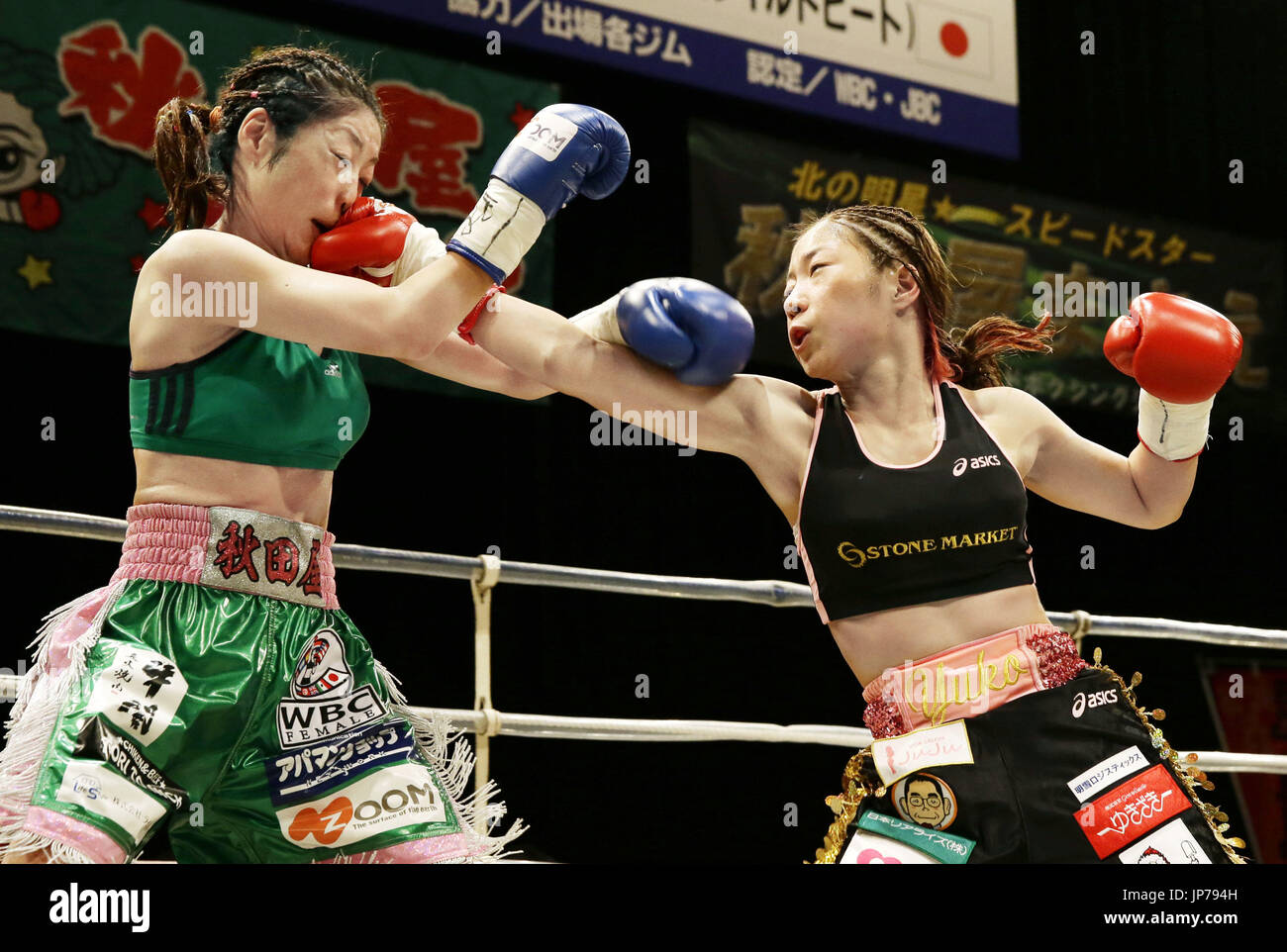 Japan's Yuko Kuroki (R) delivers a punch to compatriot Masae Akitaya in the fourth round of ...