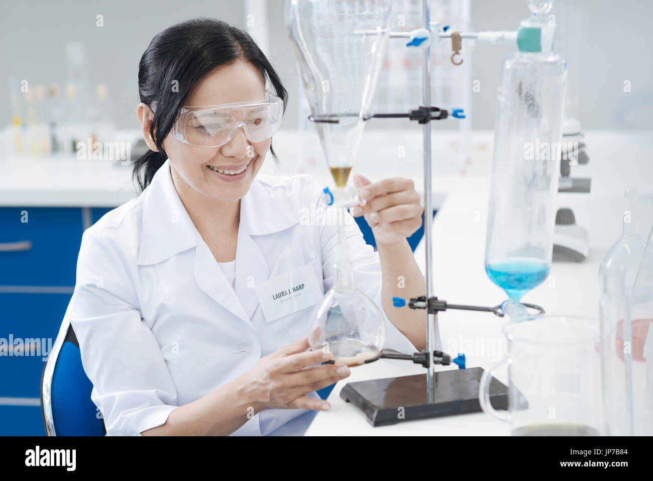 Happy smart scientist sitting at the table Stock Photo - Alamy