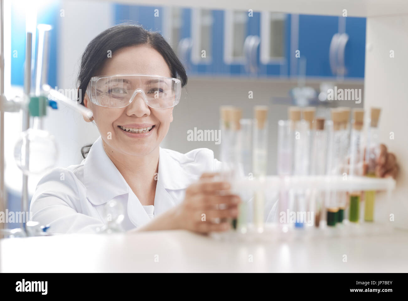 Happy positive chemist standing near the test tube rack Stock Photo - Alamy