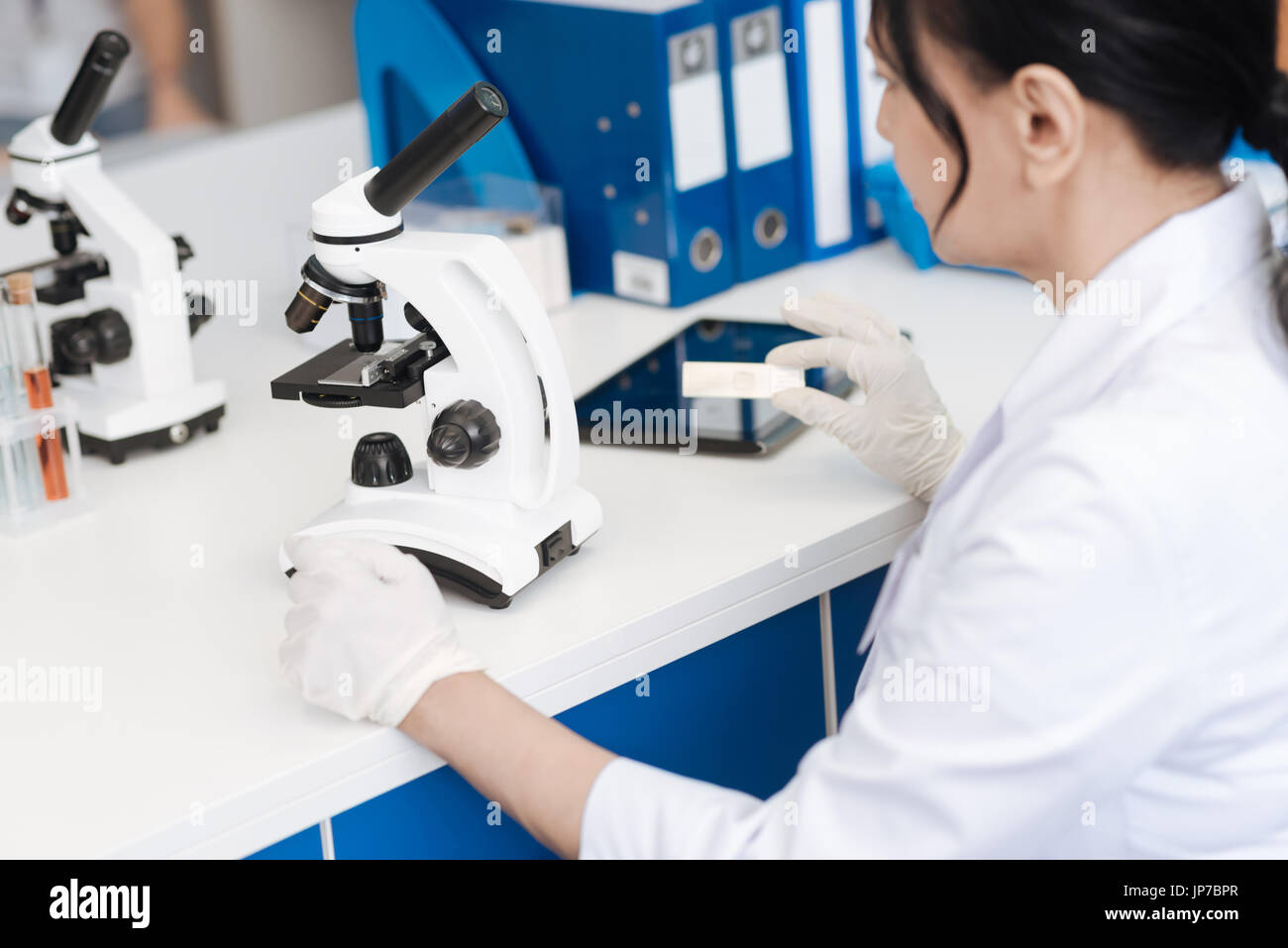 Nice intelligent woman working with a microscope Stock Photo - Alamy