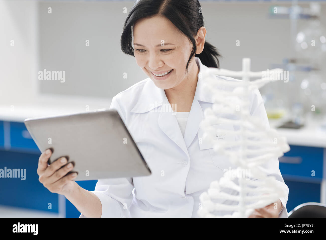 Joyful positive woman looking at the tablet screen Stock Photo - Alamy