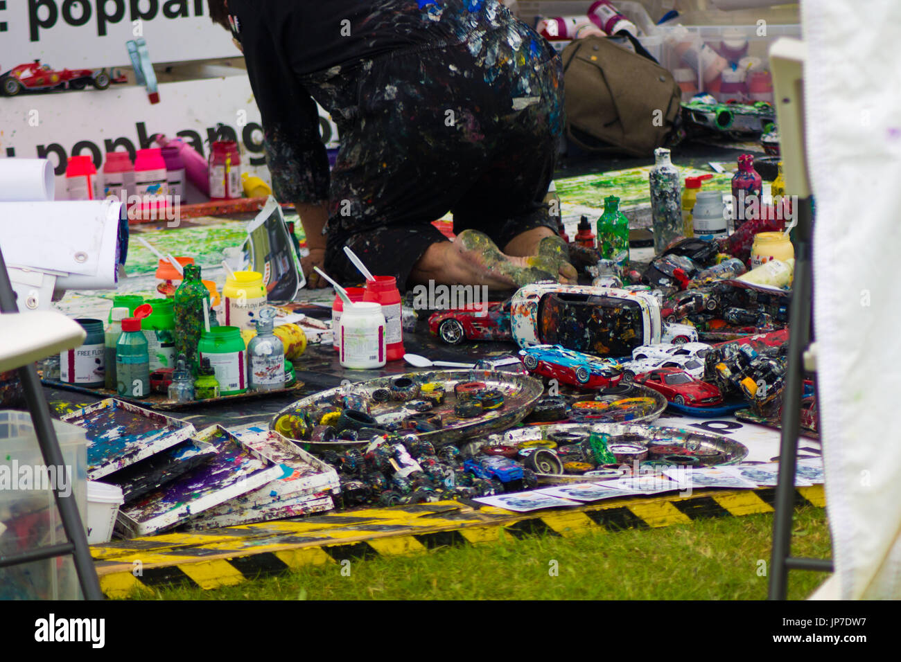 Artist known as Pop Bang Colour hard at work painting with toy cars ...