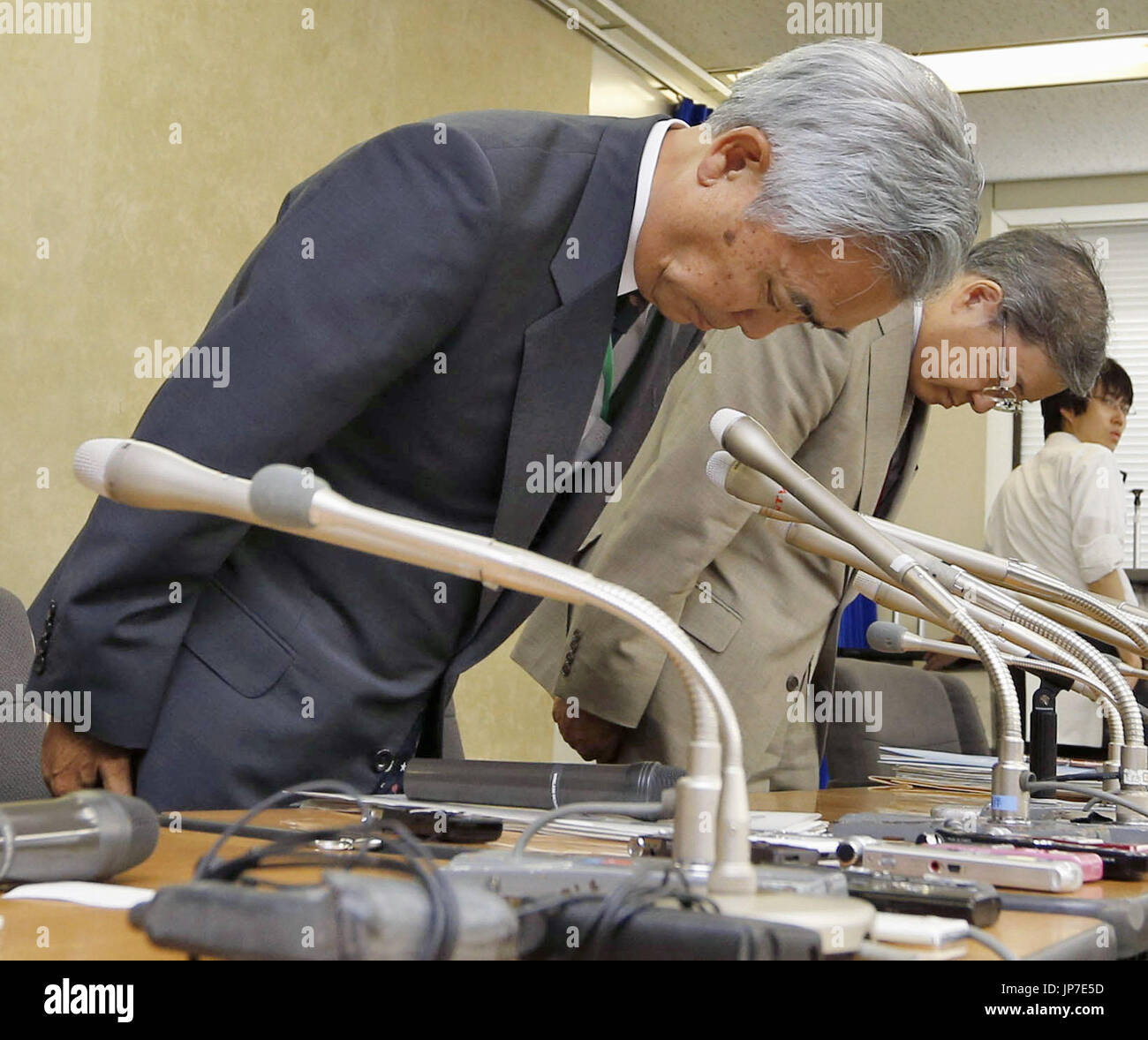 Toichiro Mizushima (front), head of the Japan Pension Service, offers ...