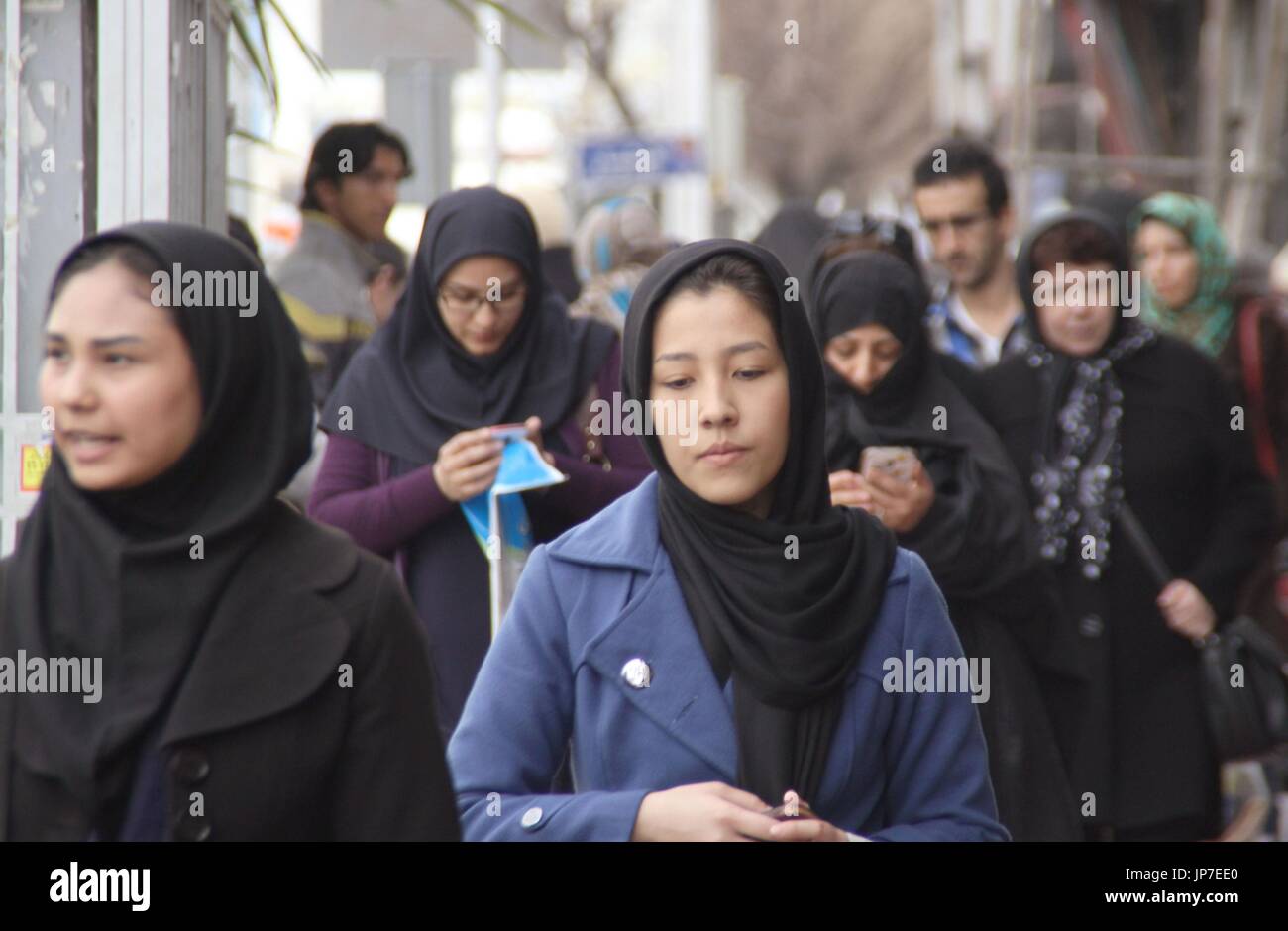 Iranian women wearing headscarves to cover their hair in accordance ...
