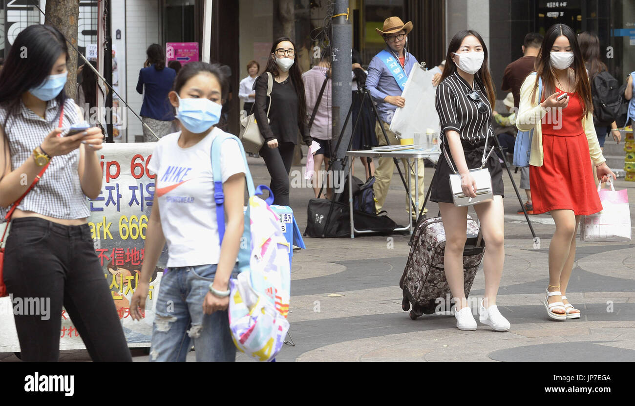 Tourists walk while wearing masks in the Myeongdong sightseeing ...