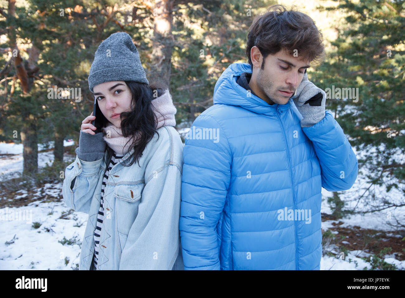 Boyfriend and girlfriend couple are talking on the phone while they are ...