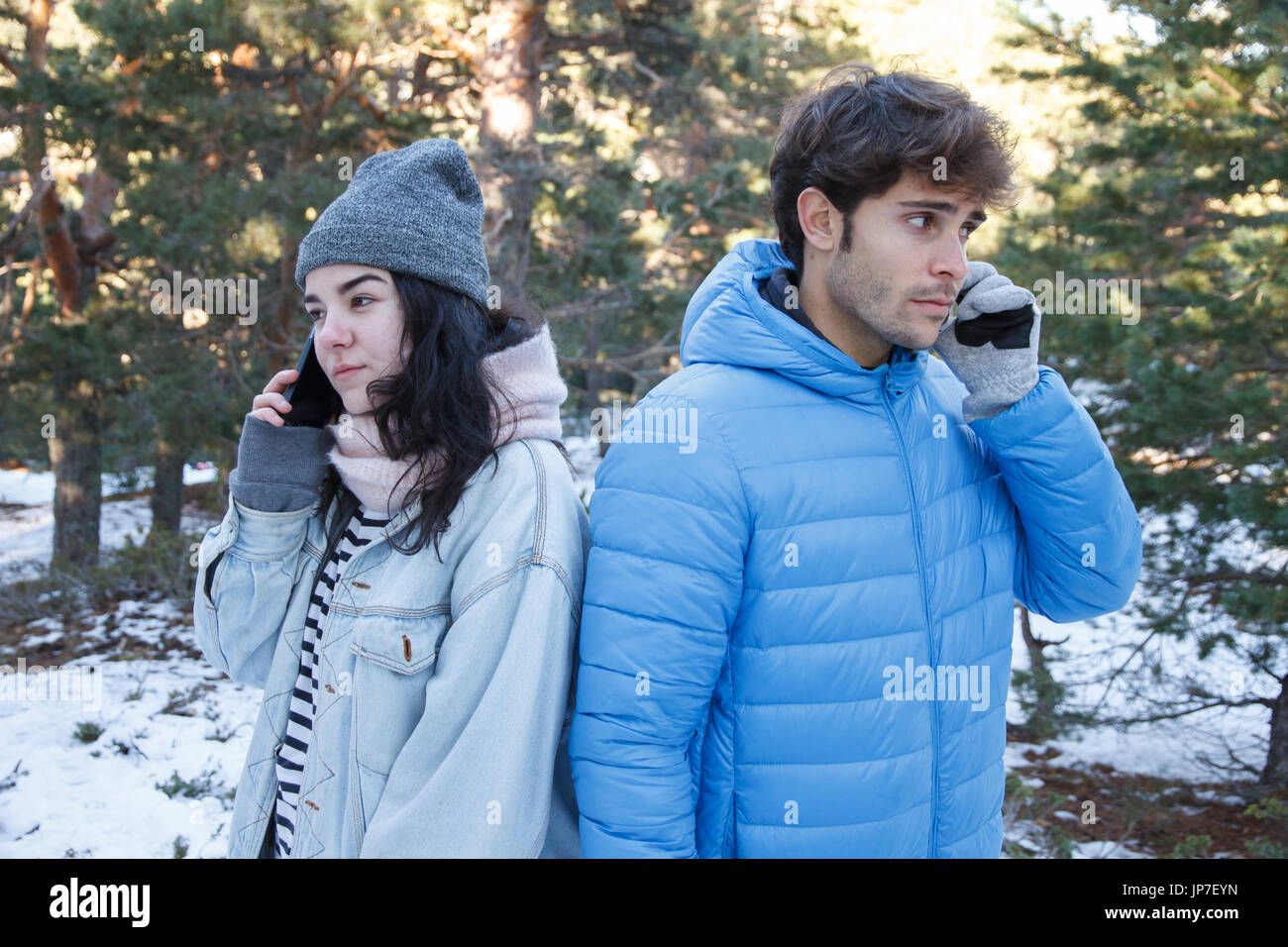 Boyfriend and girlfriend couple are talking on the phone while they are ...