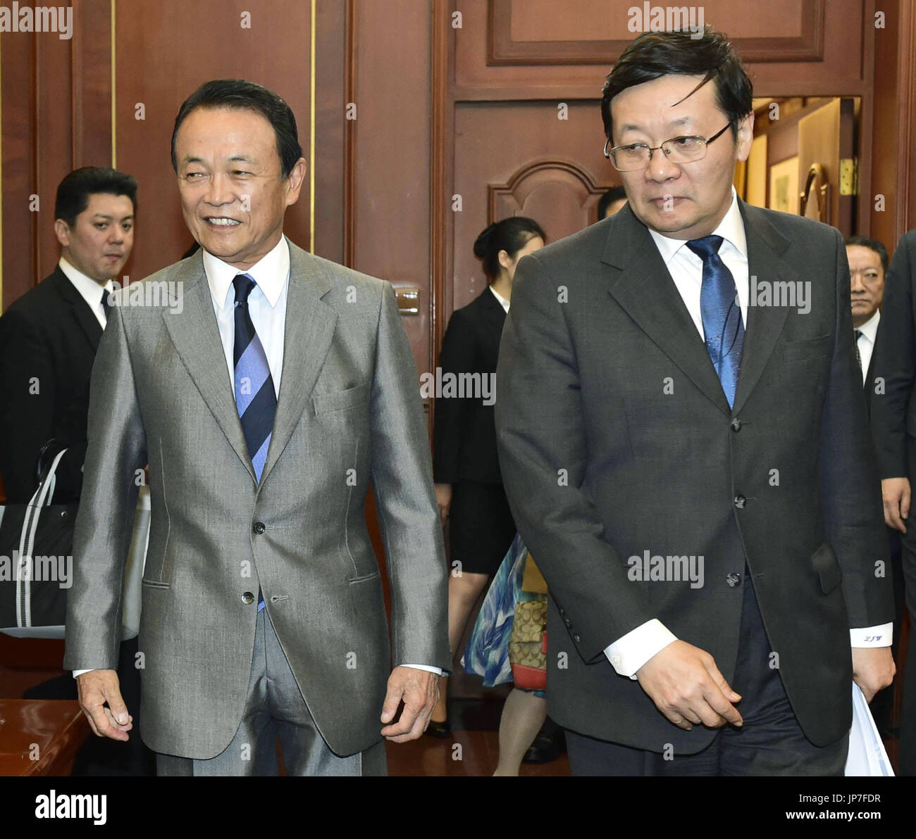 Japanese Finance Minister Taro Aso (L) and his Chinese counterpart Lou Jiwei head for their ...