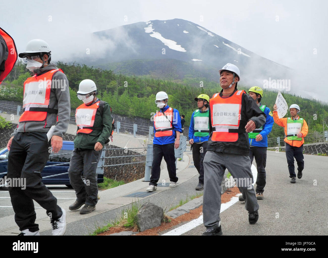 Participants in a drill simulating a volcanic eruption at Mt. Fuji ...