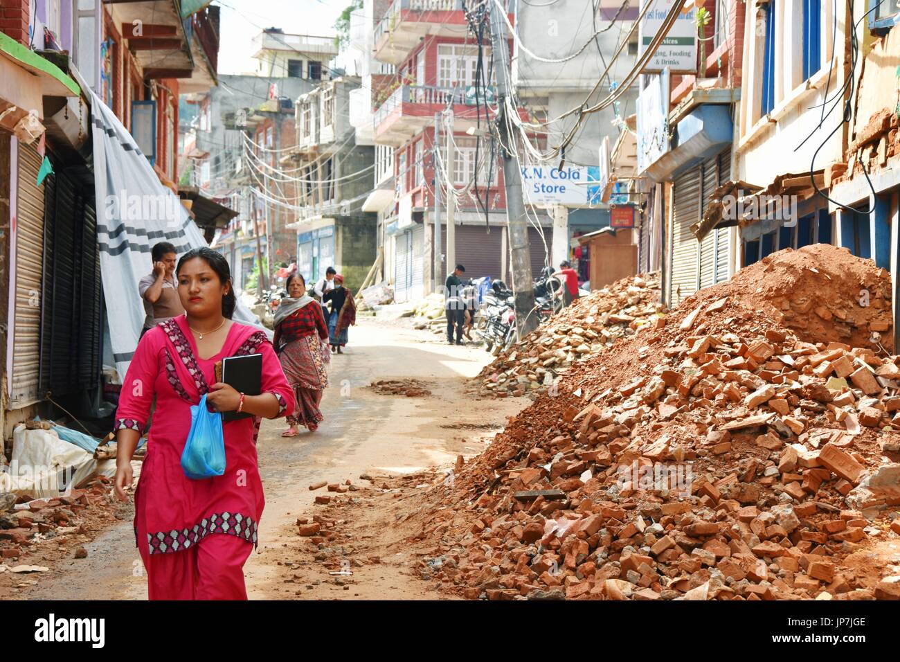 People walk past piles of debris in Chautara, northeastern Nepal, on ...