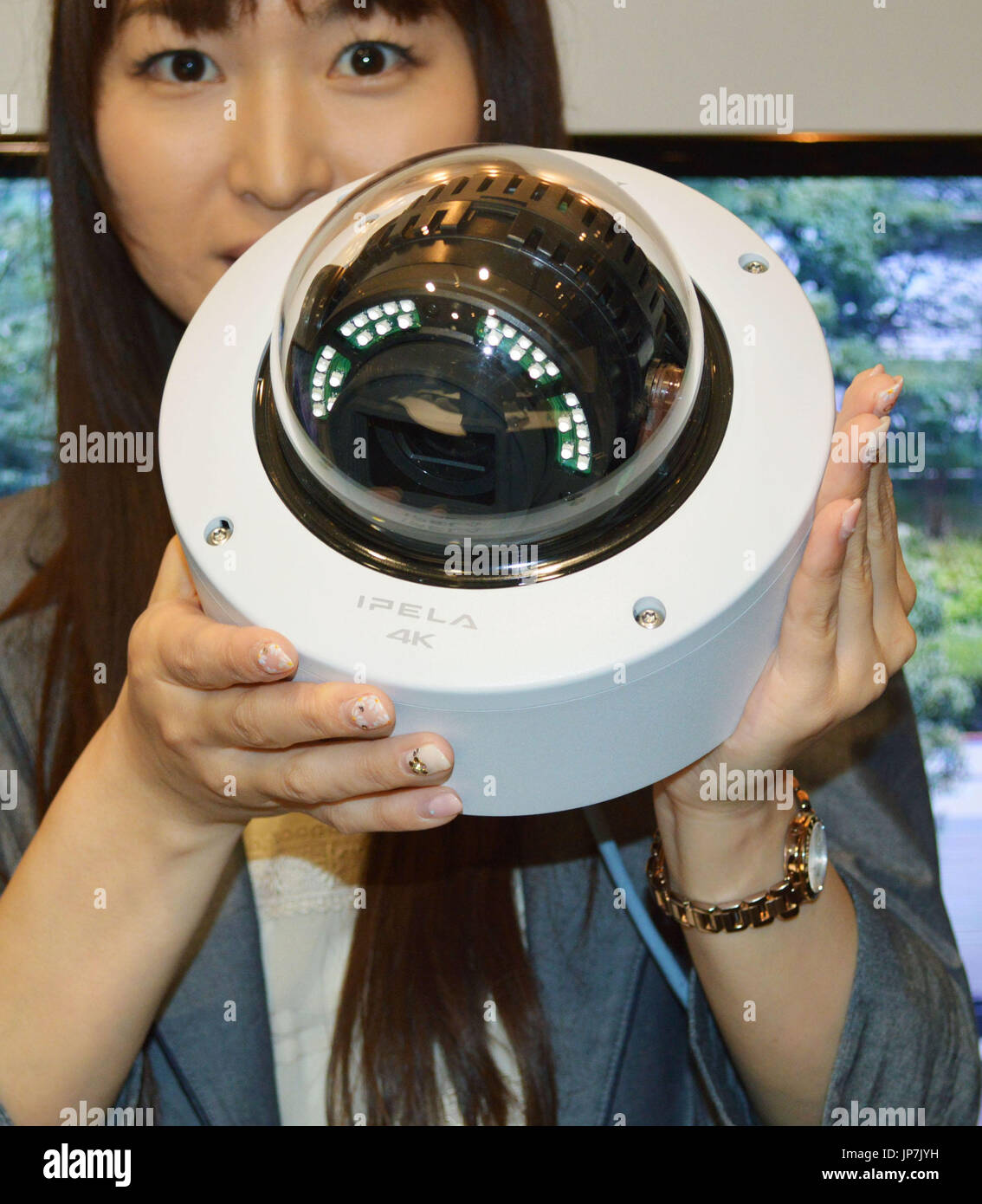 A woman holds up a network security camera capable of recording super ...