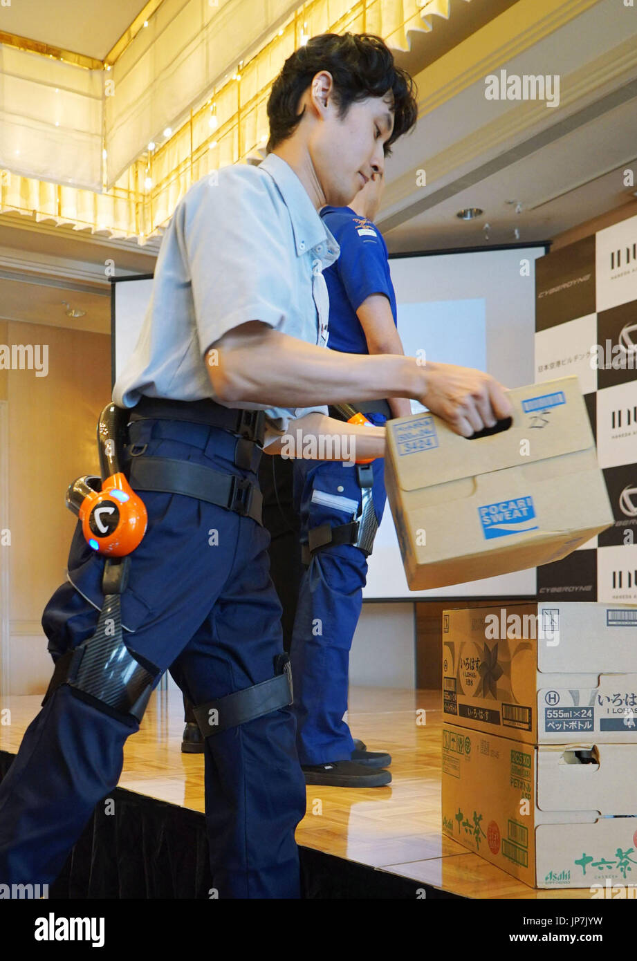 A man wearing a "HAL" robot suit carries a box at Tokyo's Haneda ...
