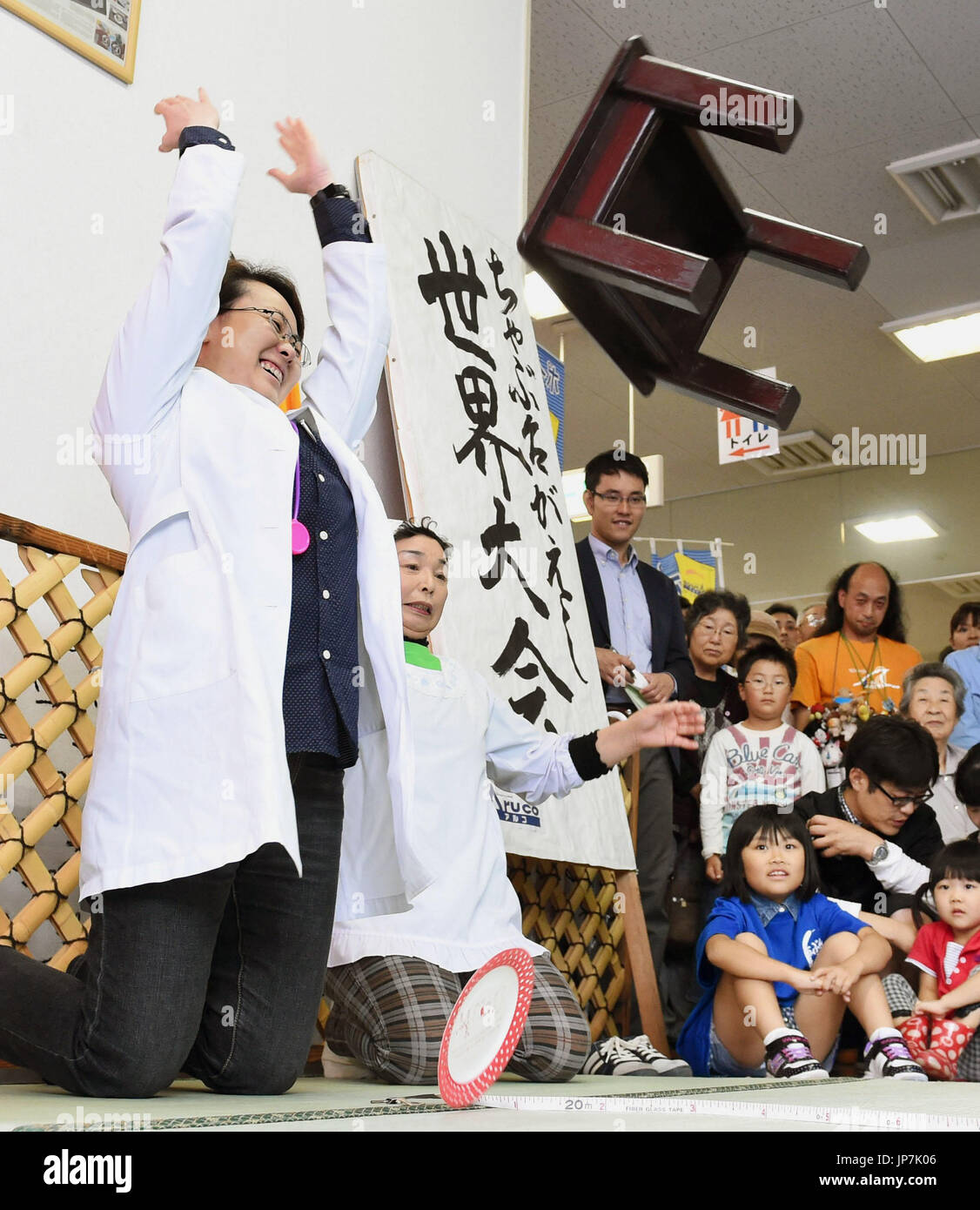 A female participant (L) dressed as a doctor overturns a Japanese ...