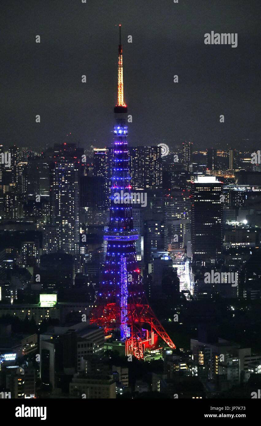 Tokyo Tower is lit up in blue, pink and white -- the same colors as ...