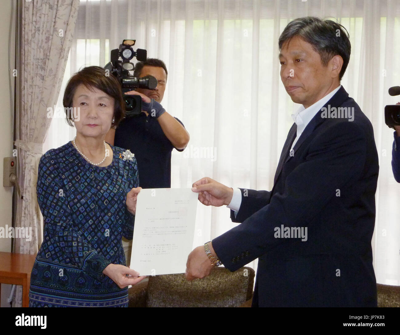 Yokohama Mayor Fumiko Hayashi (L) receives a notice on the return of ...