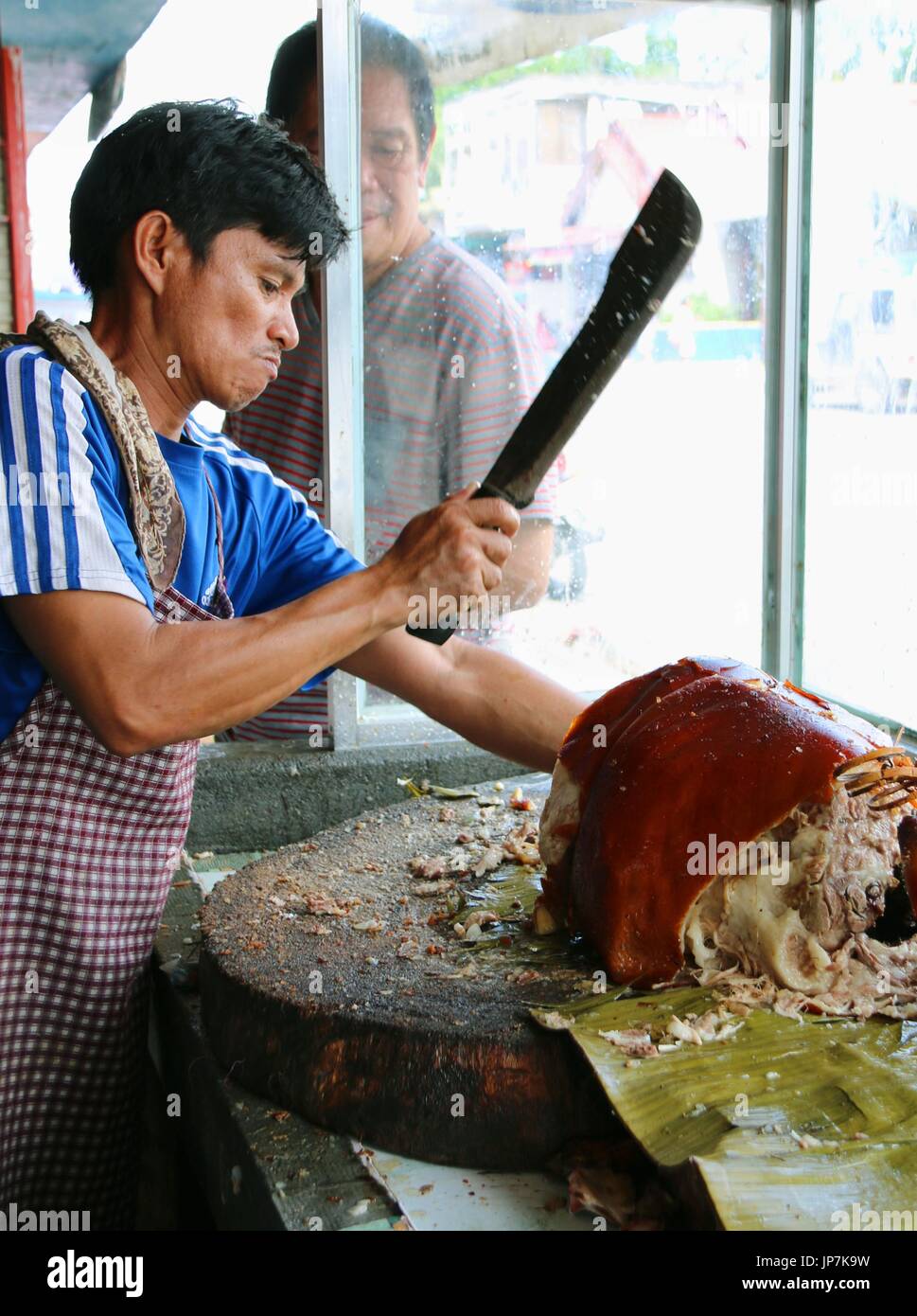 A man cuts a whole roasted pig called the lechon in Cotabato on the ...