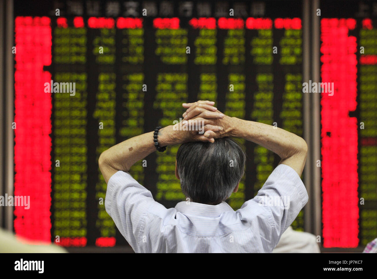A Chinese man looks up at a stock price board in Beijing on July 2 ...