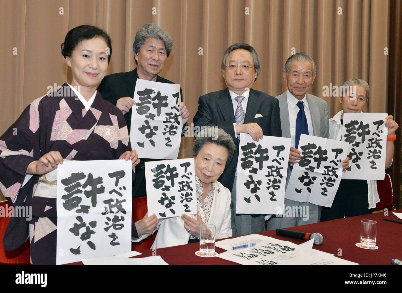 Influential writer Hisae Sawachi (3rd from L) and others hold messages ...