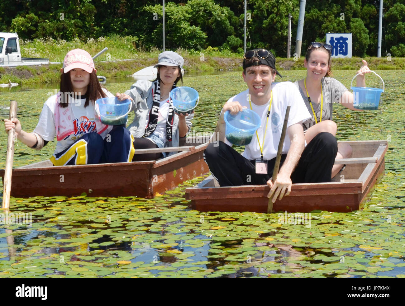 Participants show off their harvest in a water shield gathering ...