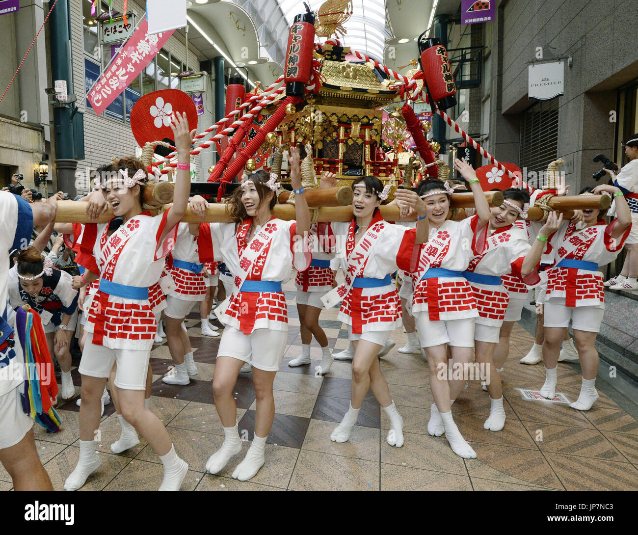 Some 100 women parade through a shopping street in Osaka, western Japan ...