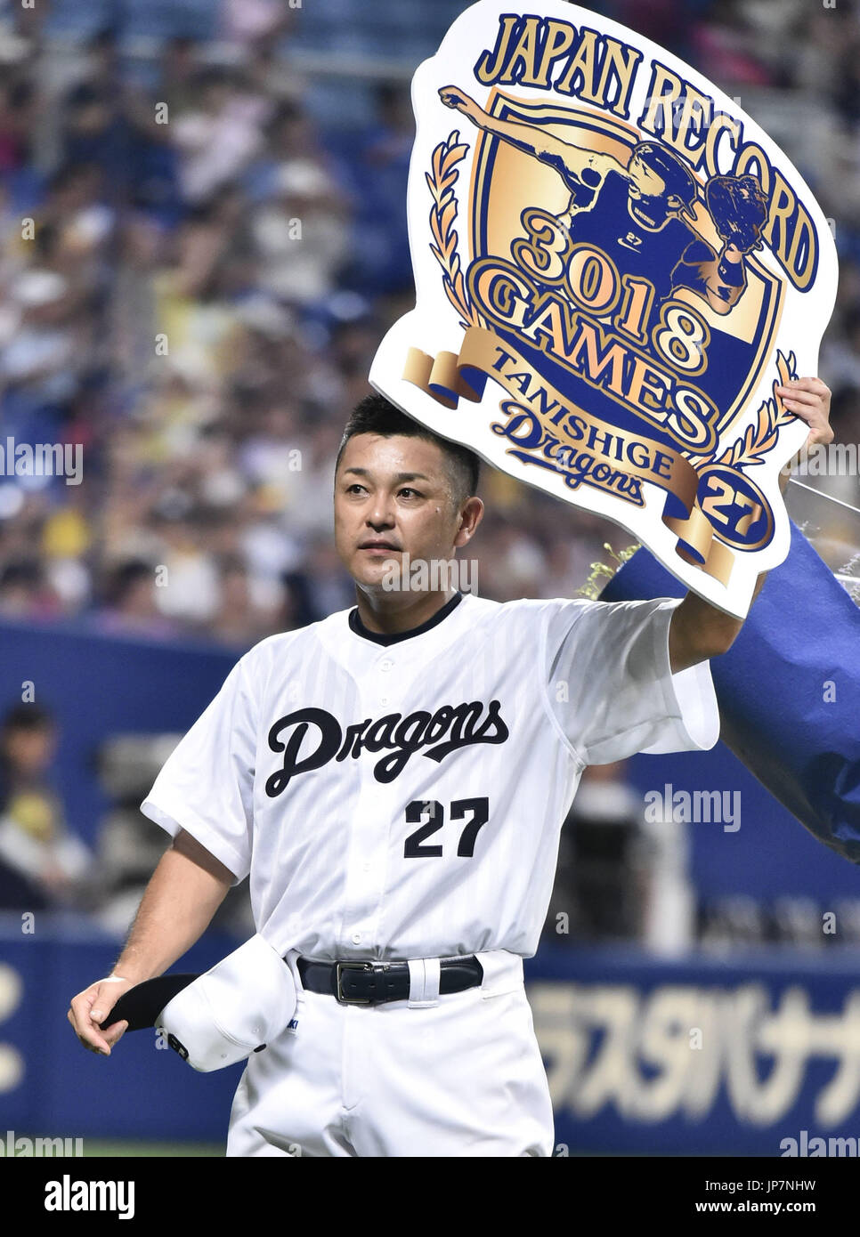 Dragons player-manager Motonobu Tanishige holds up a sign marking his 3 ...