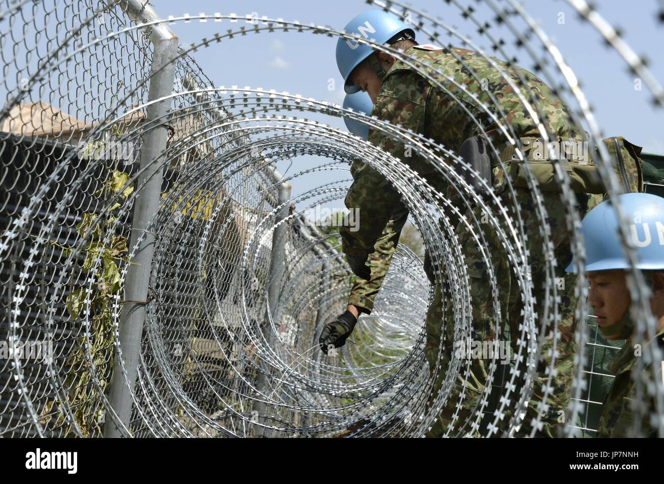 Members of a Japanese Ground Self-Defense Force unit work on a fence at ...