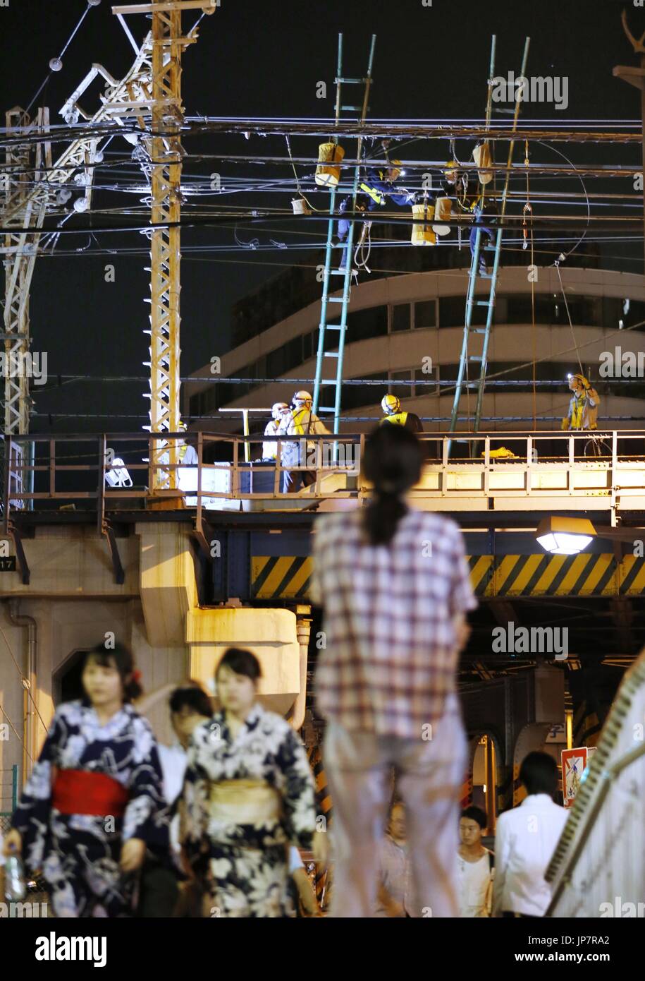 Railway workers repair a broken overhead cable in Yokohama on the JR ...
