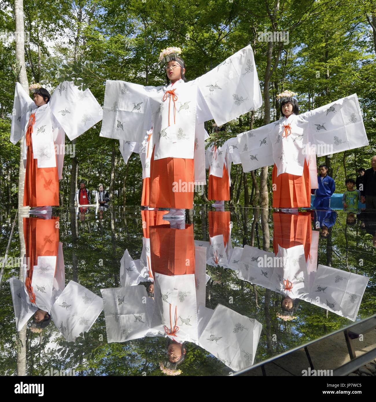Elementary school girls clad in traditional Shinto costumes dance on a ...