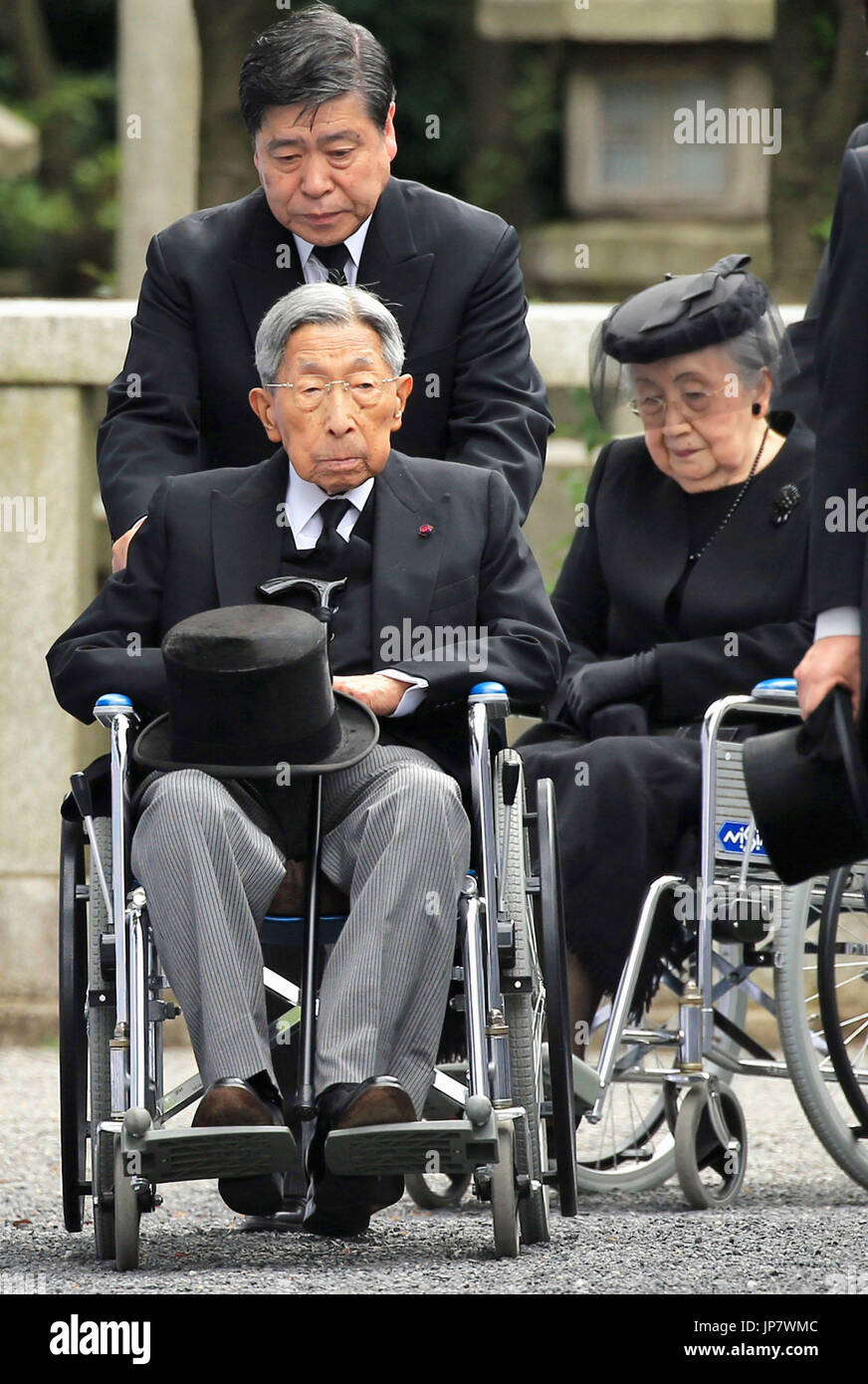 Prince Mikasa and his wife, Princess Yoriko, are pushed in wheelchairs ...