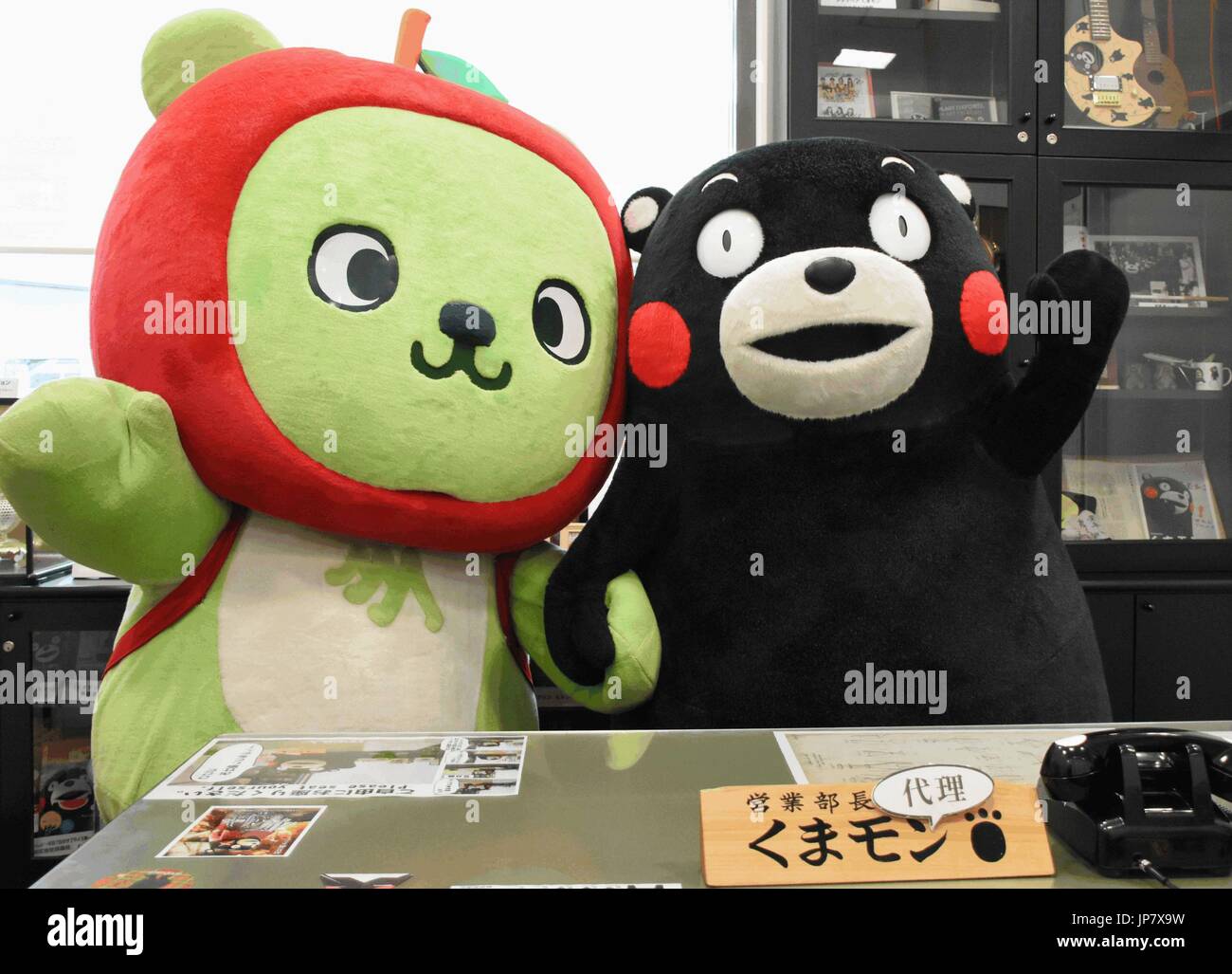Apple-bear mascot Arukuma (L) and black bear mascot Kumamon hold hands ...
