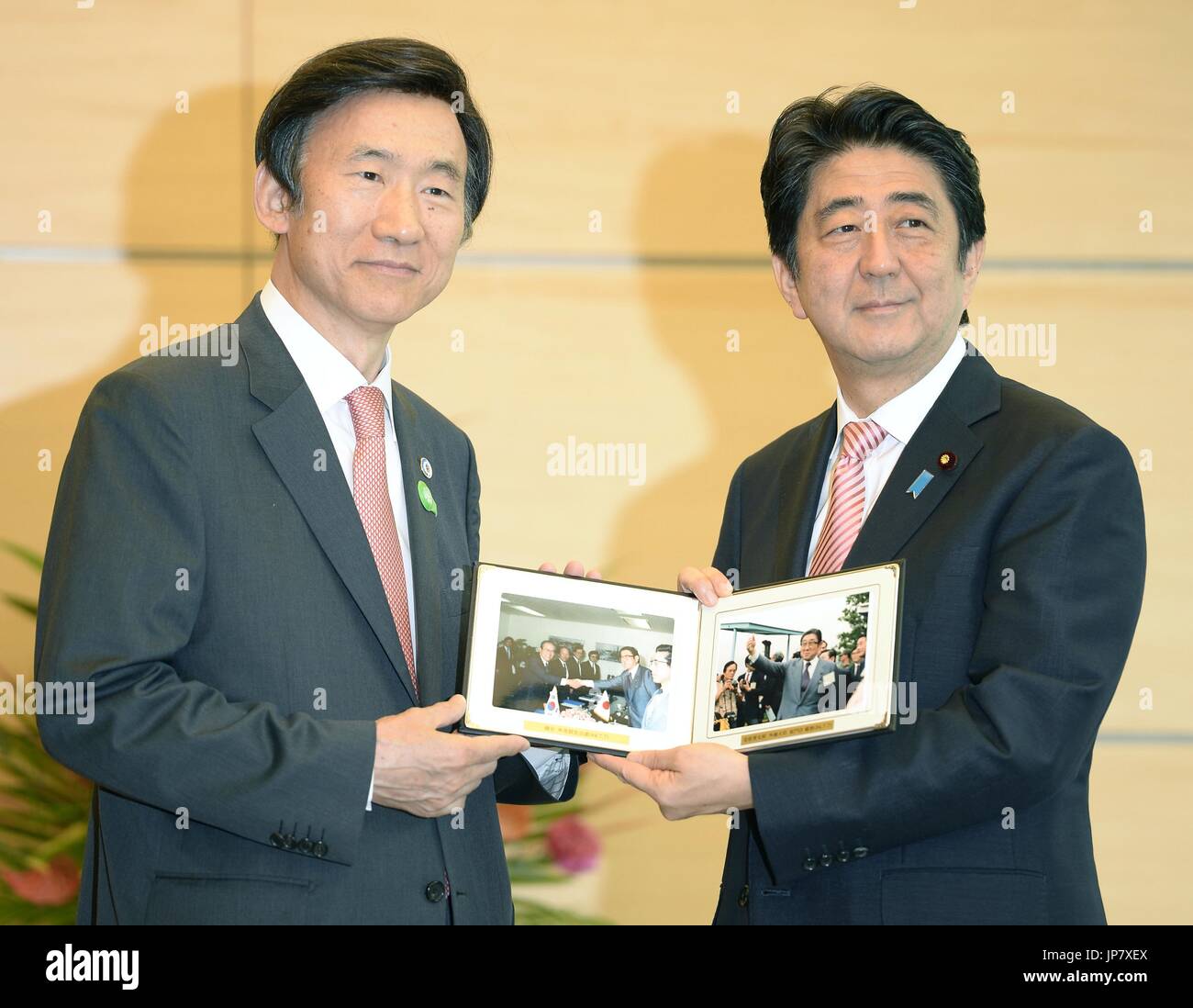 Japanese Prime Minister Shinzo Abe (R) is handed pictures of his late ...