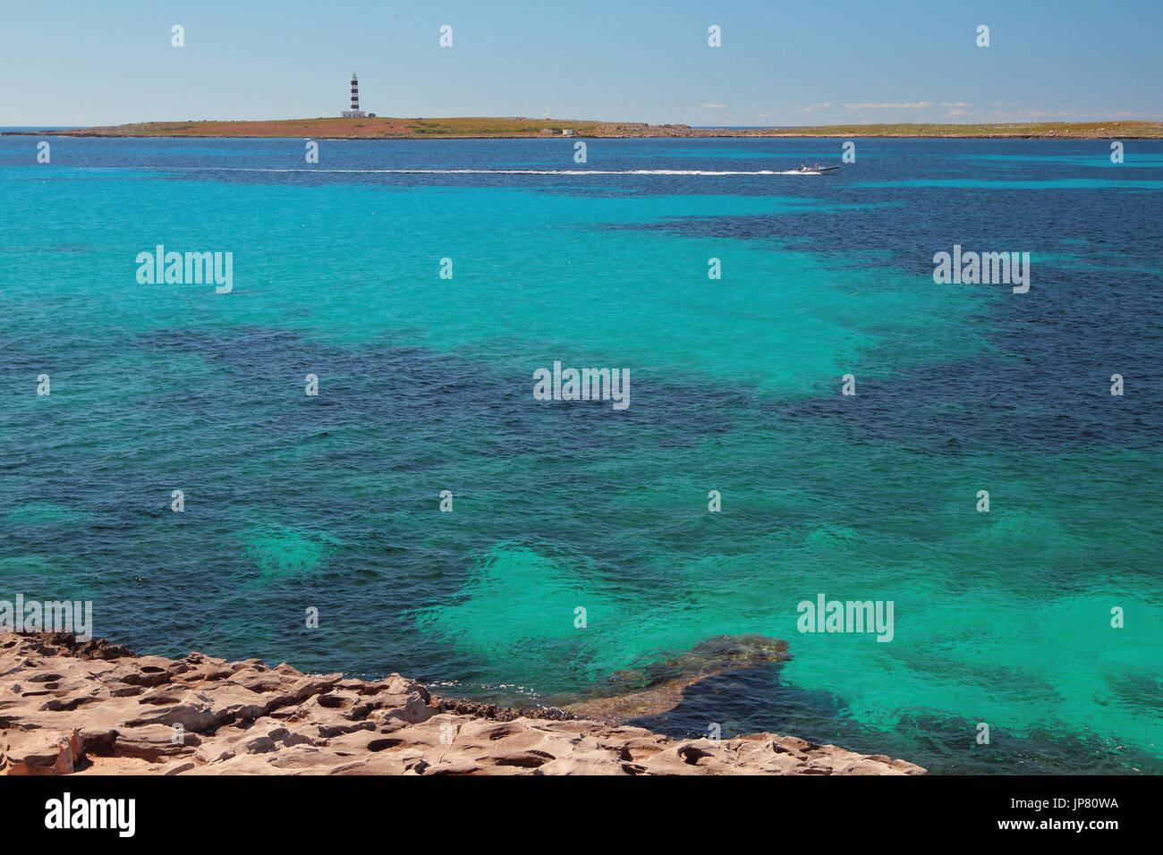 Sea gulf and island with beacon. Punta Prima, Minorca, Spain Stock ...