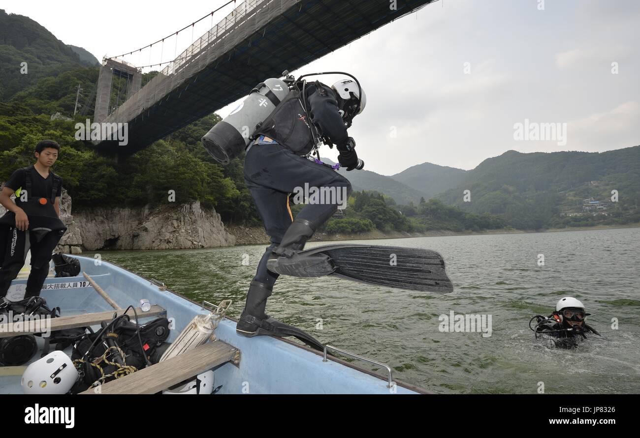 A diver(C) belonging to the Diving Search and Rescue Association dives ...