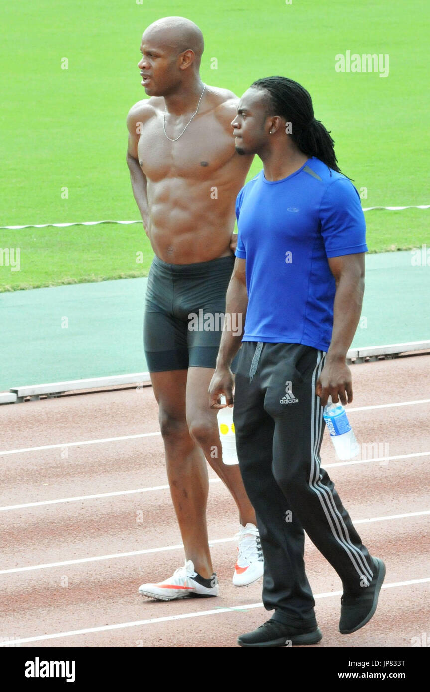 Former 100-meter world record holder Asafa Powell (L) trains with ...