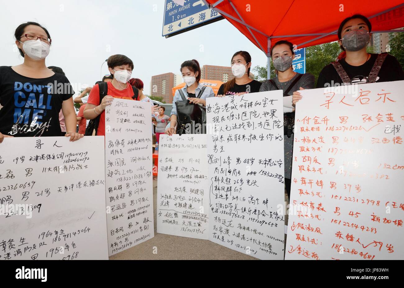 People hold boards as they seek information about missing persons on ...