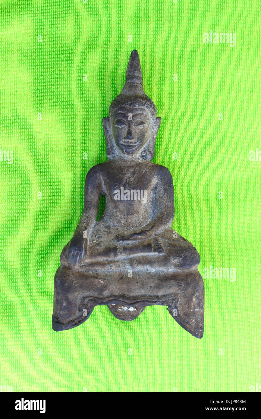 Sacred buddhist clay objects on green cloth Stock Photo - Alamy
