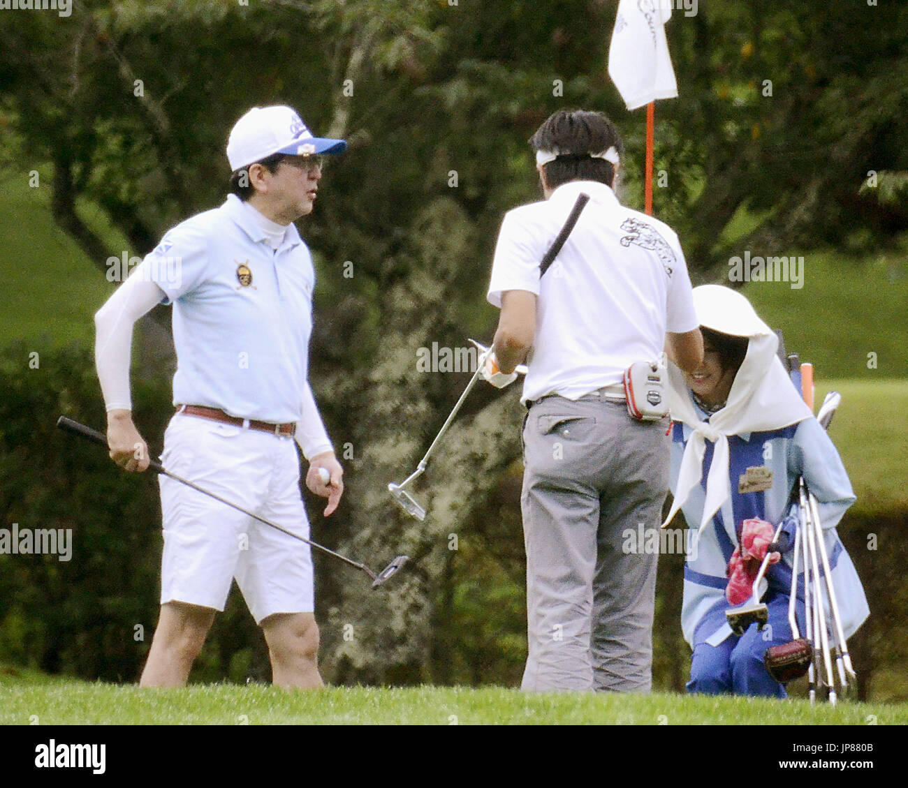 Prime Minister Shinzo Abe (far L) plays golf in the central Japan ...