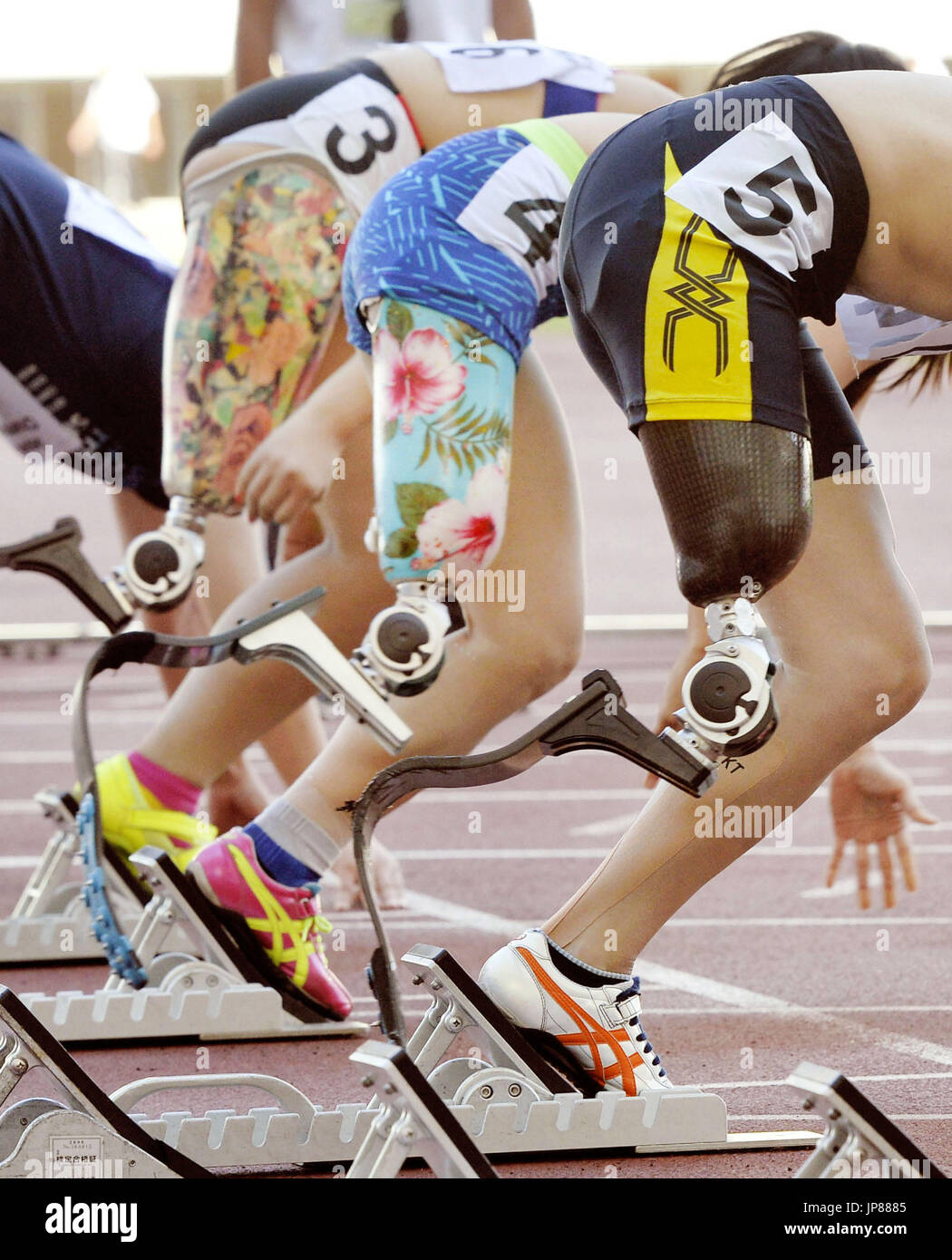 Athletes' colorful prosthetic legs are pictured at the start line of ...