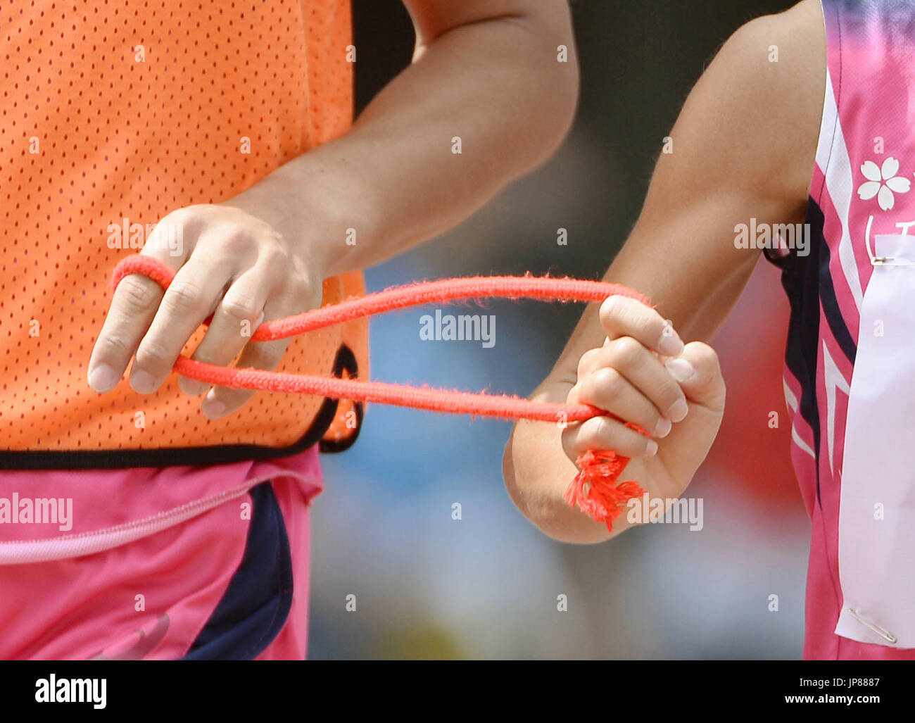 A visually impaired athlete (R) and her guide runner hold onto a rope ...