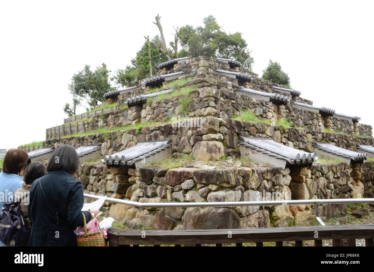 Visitors look at a pyramid-shaped Buddhist stupa in Nara, western Japan ...
