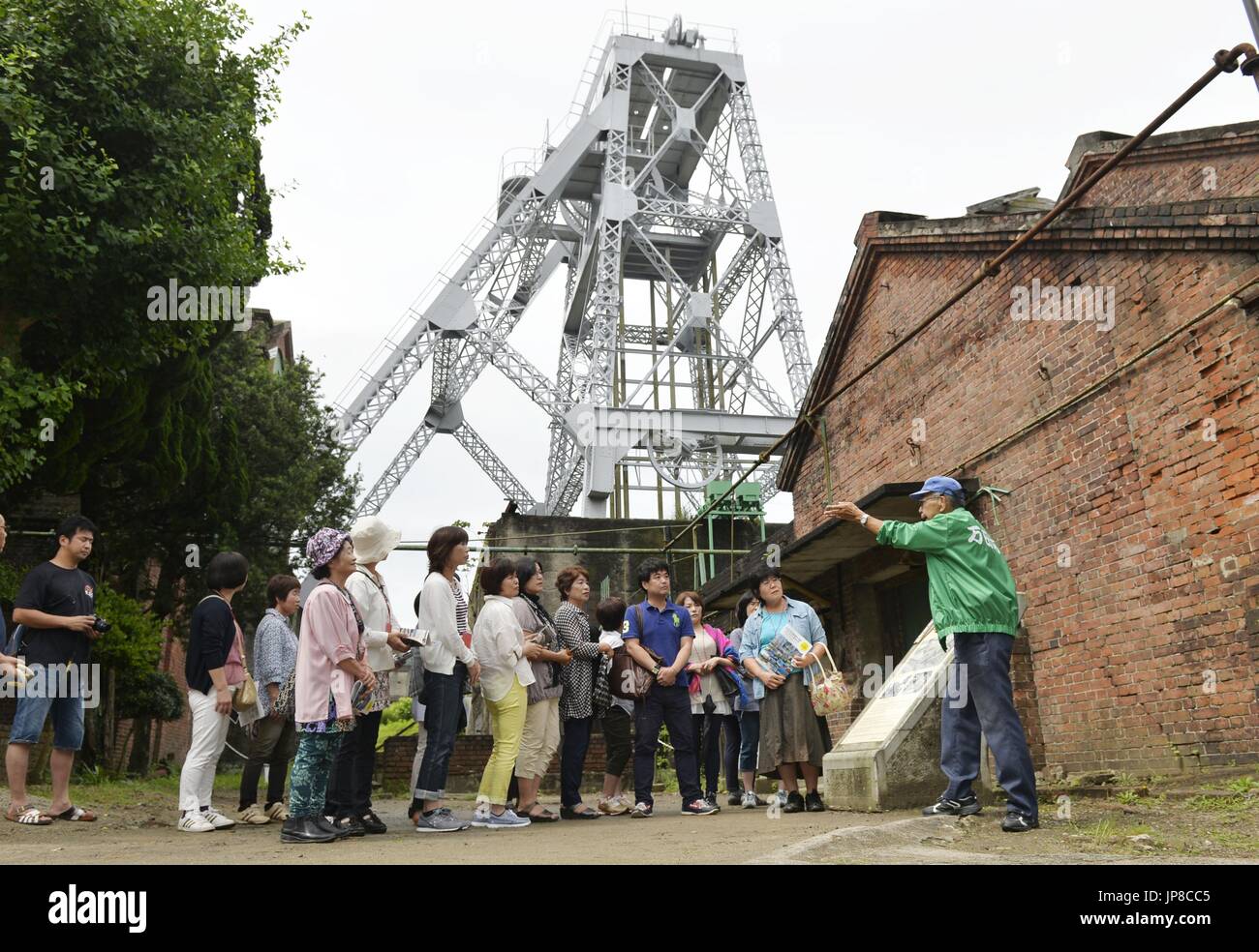 Tourists listen to a guide's explanation during a tour of the Manda pit ...