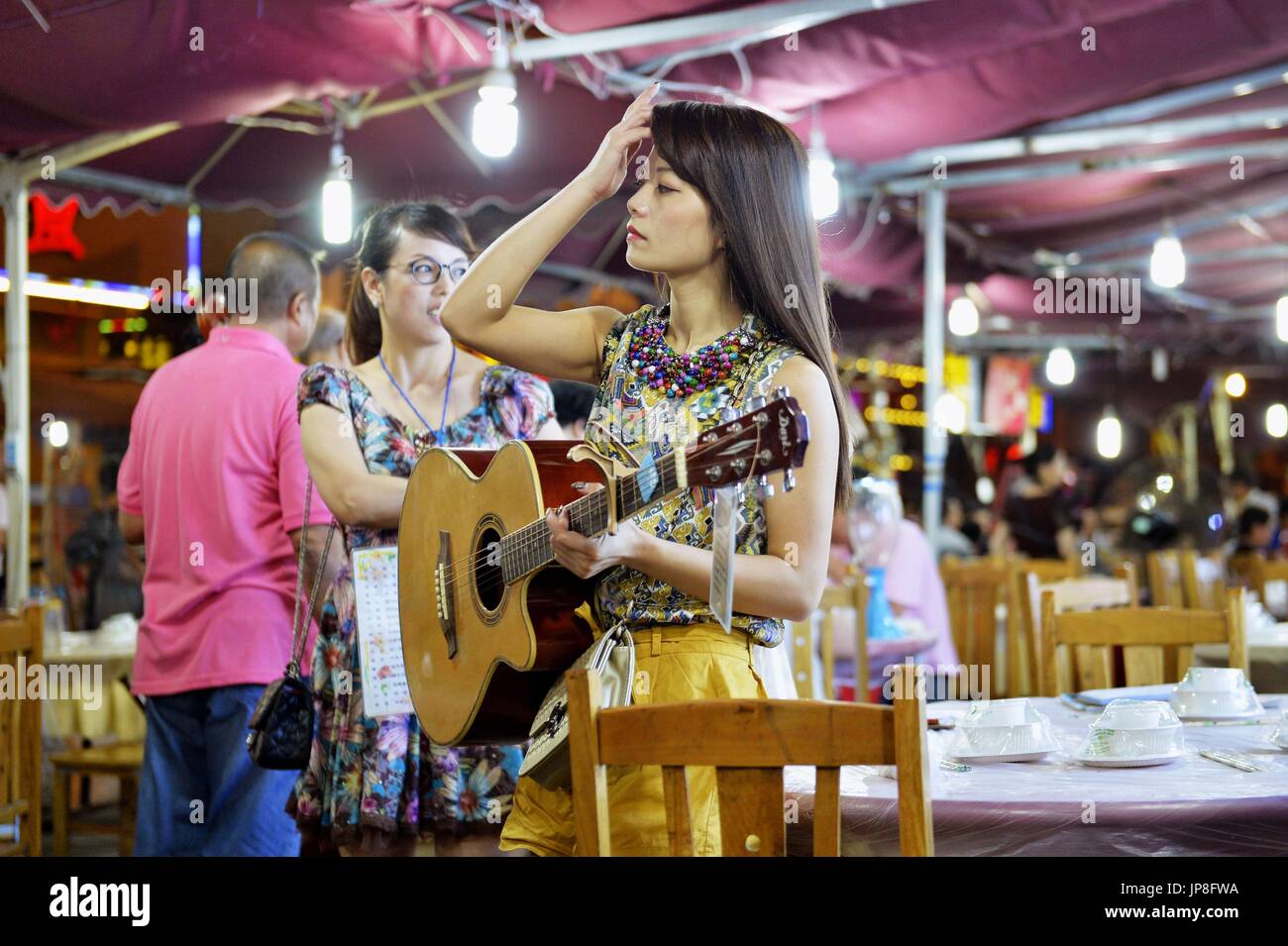 A street guitarist is pictured in downtown Wuhan in the central Chinese ...
