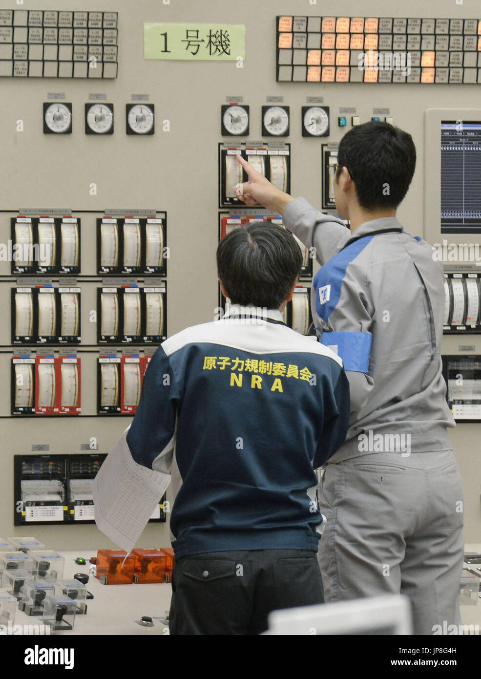 An official (front) of the Nuclear Regulation Authority conducts final ...