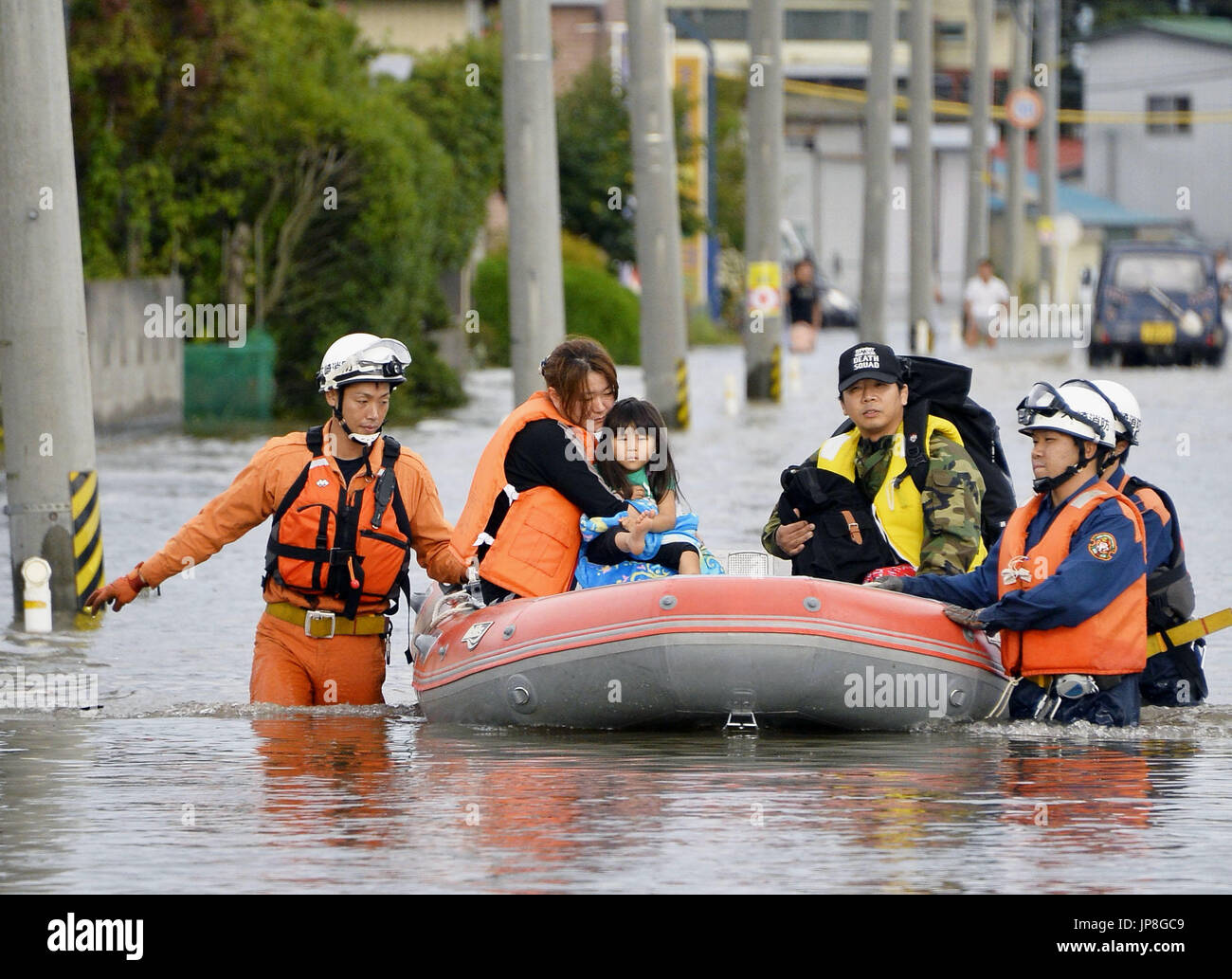 A couple and their 3-year-old daughter are rescued from a flooded area ...