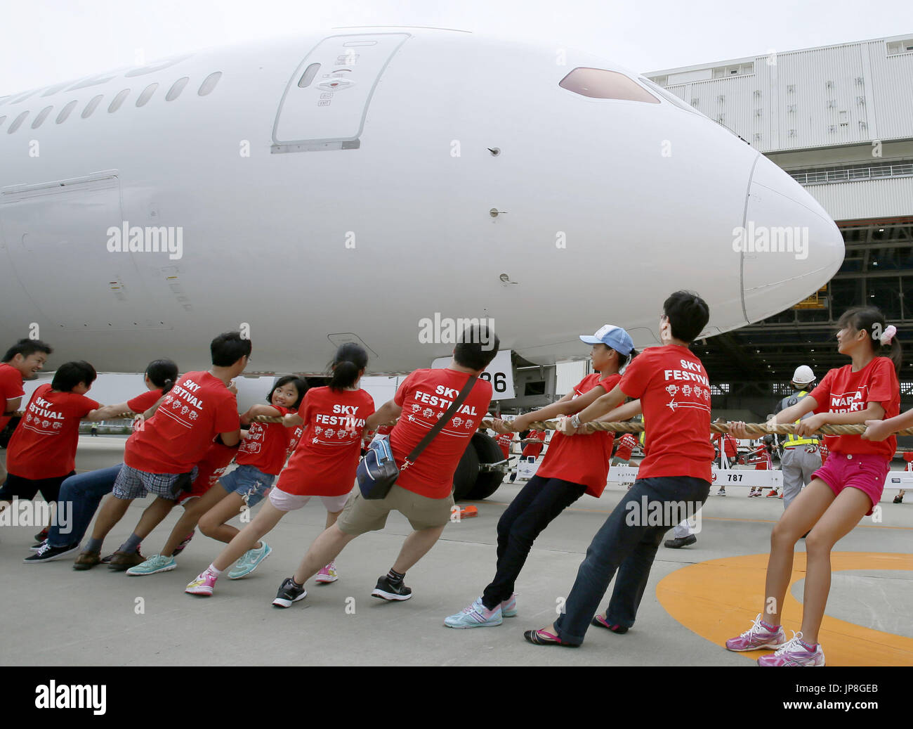 People pull a Boeing 787 aircraft weighing about 170 tons, including ...
