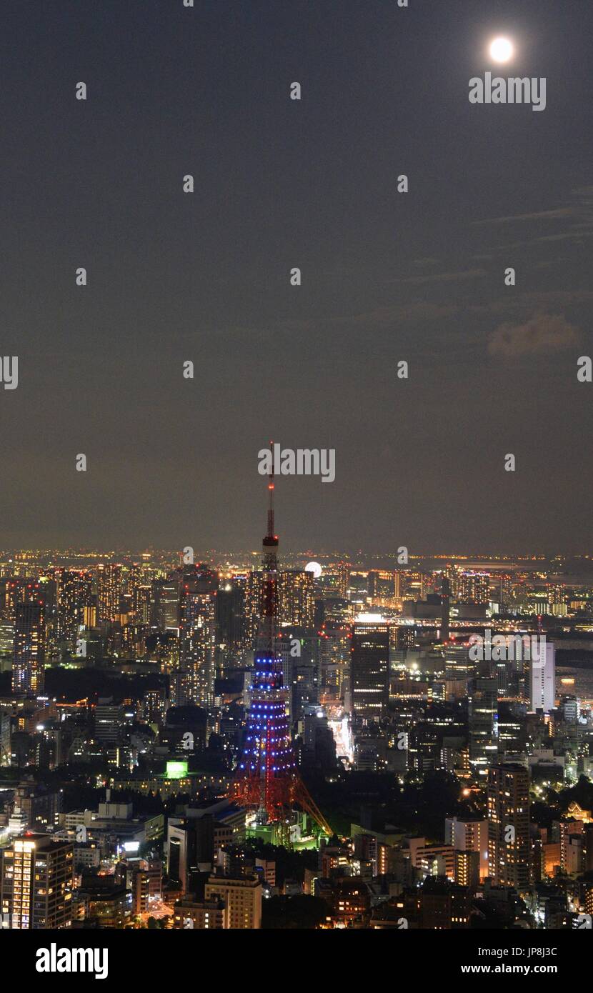 Tokyo Tower is illuminated in blue in the middle, with its lighting at ...