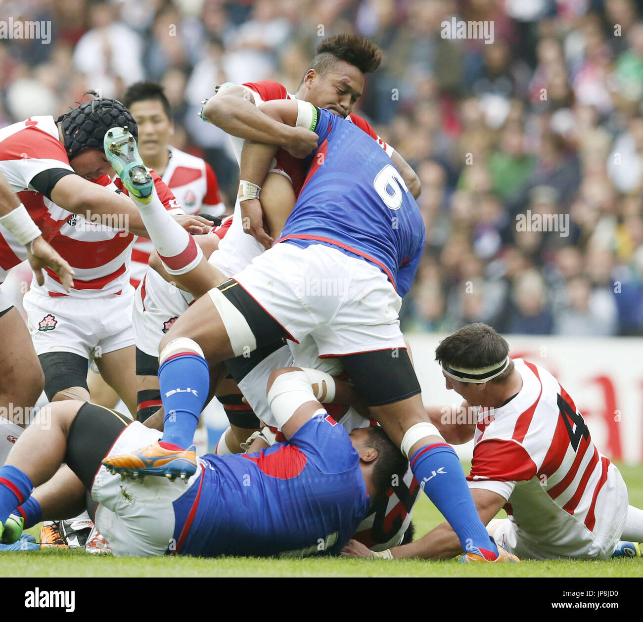 Japan's Kotaro Matsushima (C) tackles a Samoan player in the first half ...