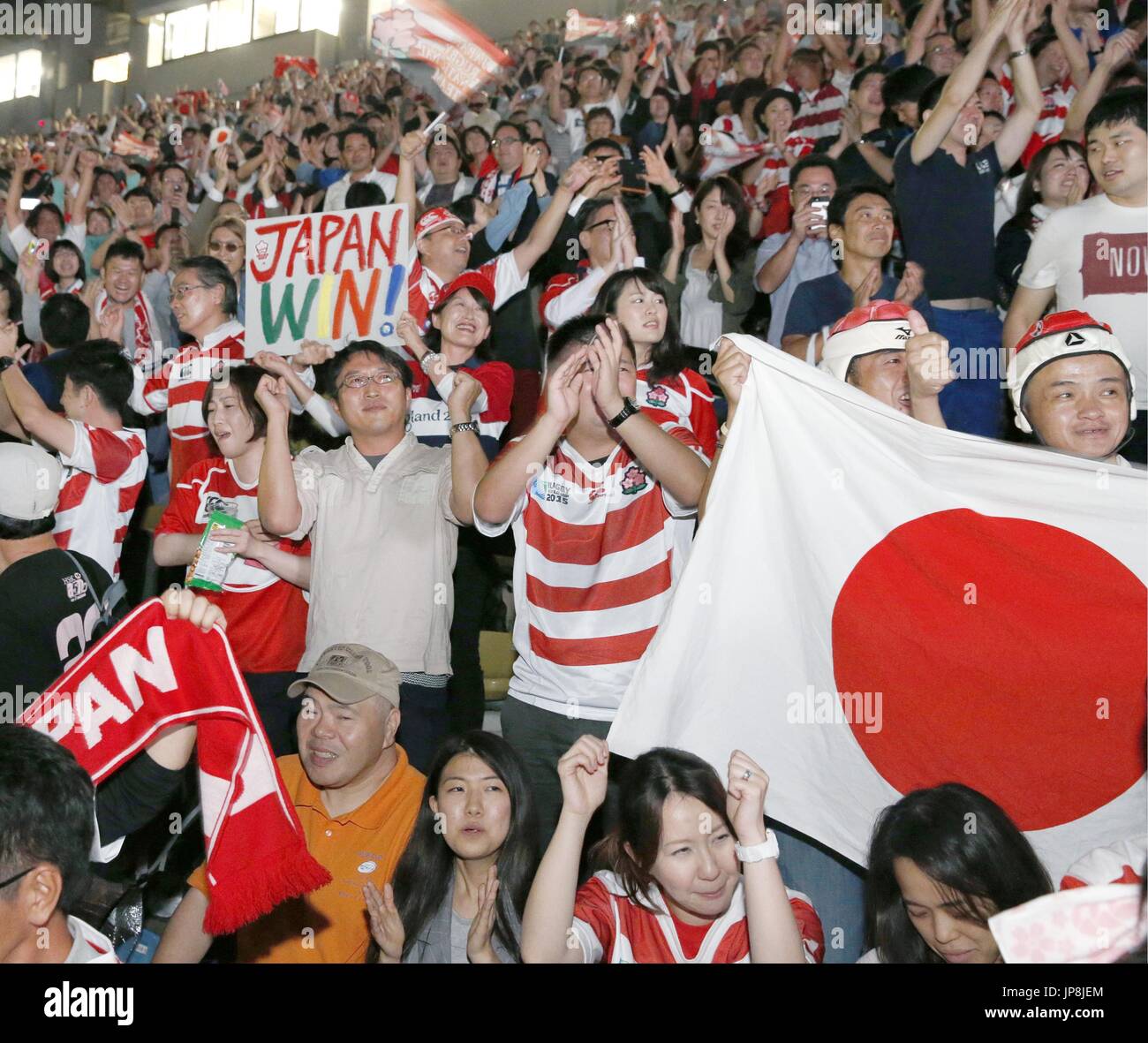 Fans celebrate during a live broadcast at a rugby stadium in Tokyo on ...