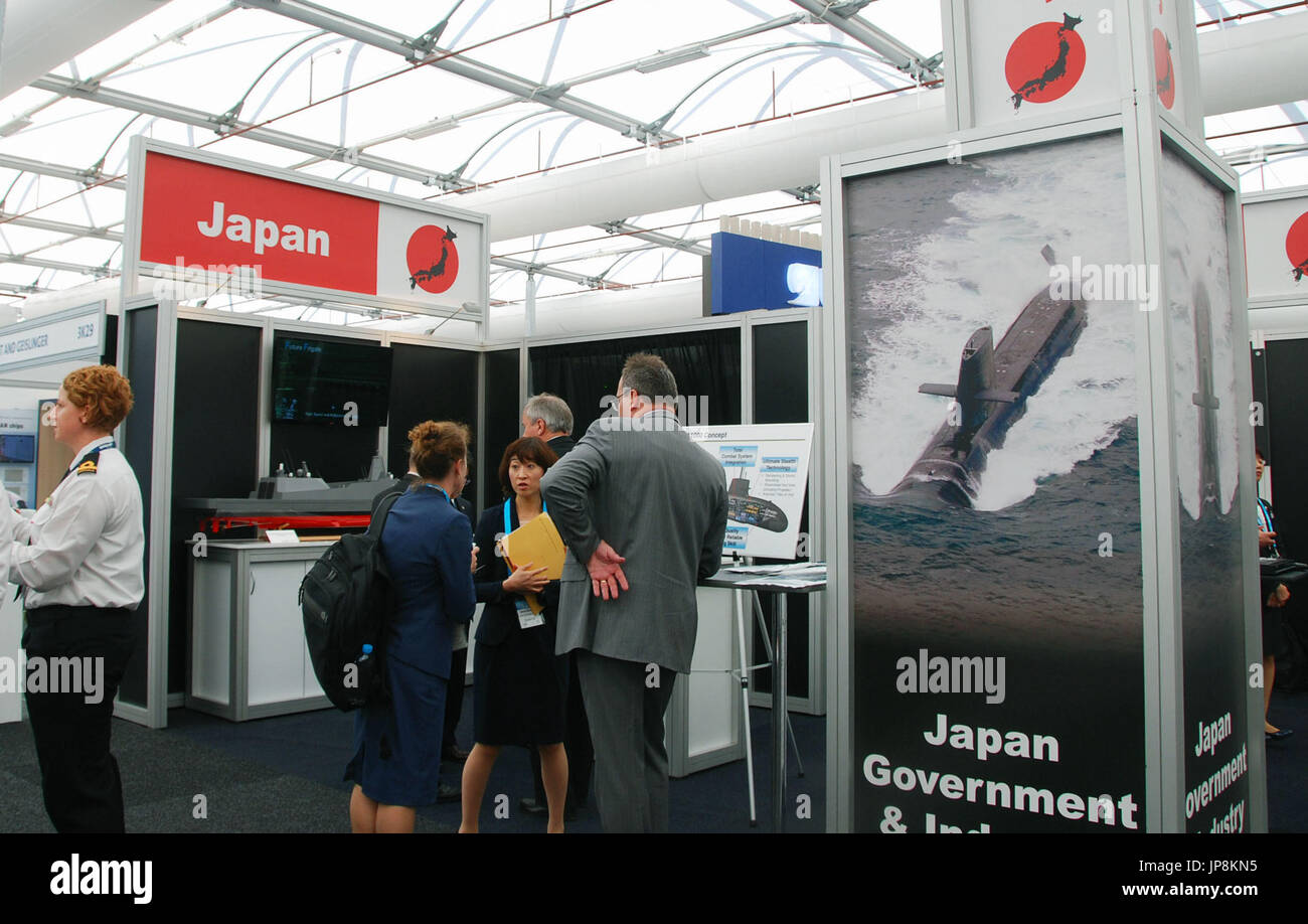 People chat at a booth opened by Japan at the International Maritime ...