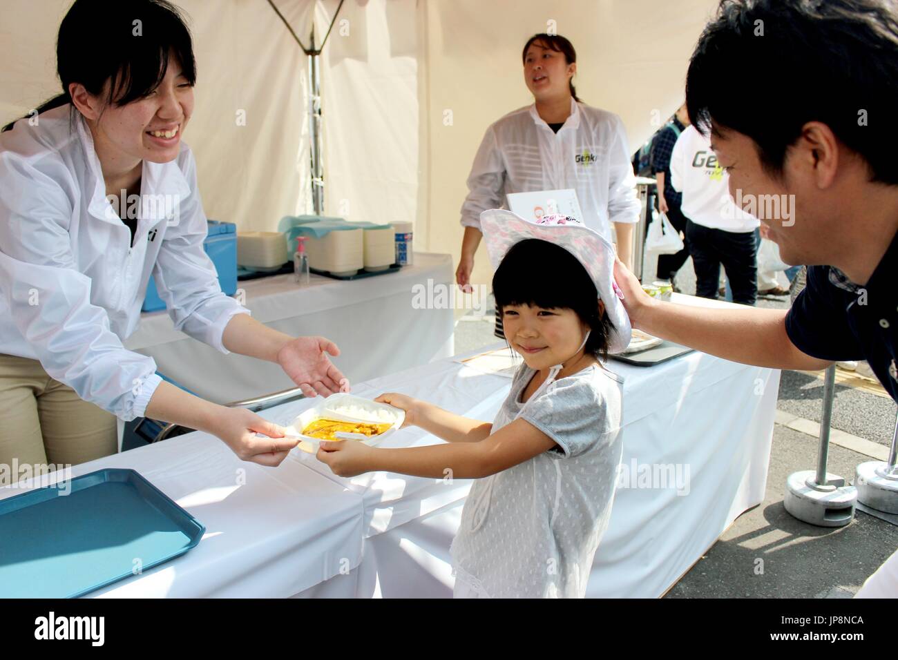 A girl receives a curry and rice dish using food materials produced in ...